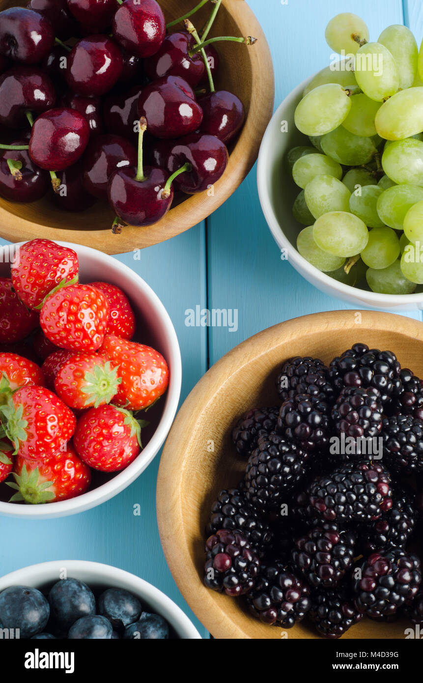 Overhead shot of five different fruit choices in separated bowlls on ...