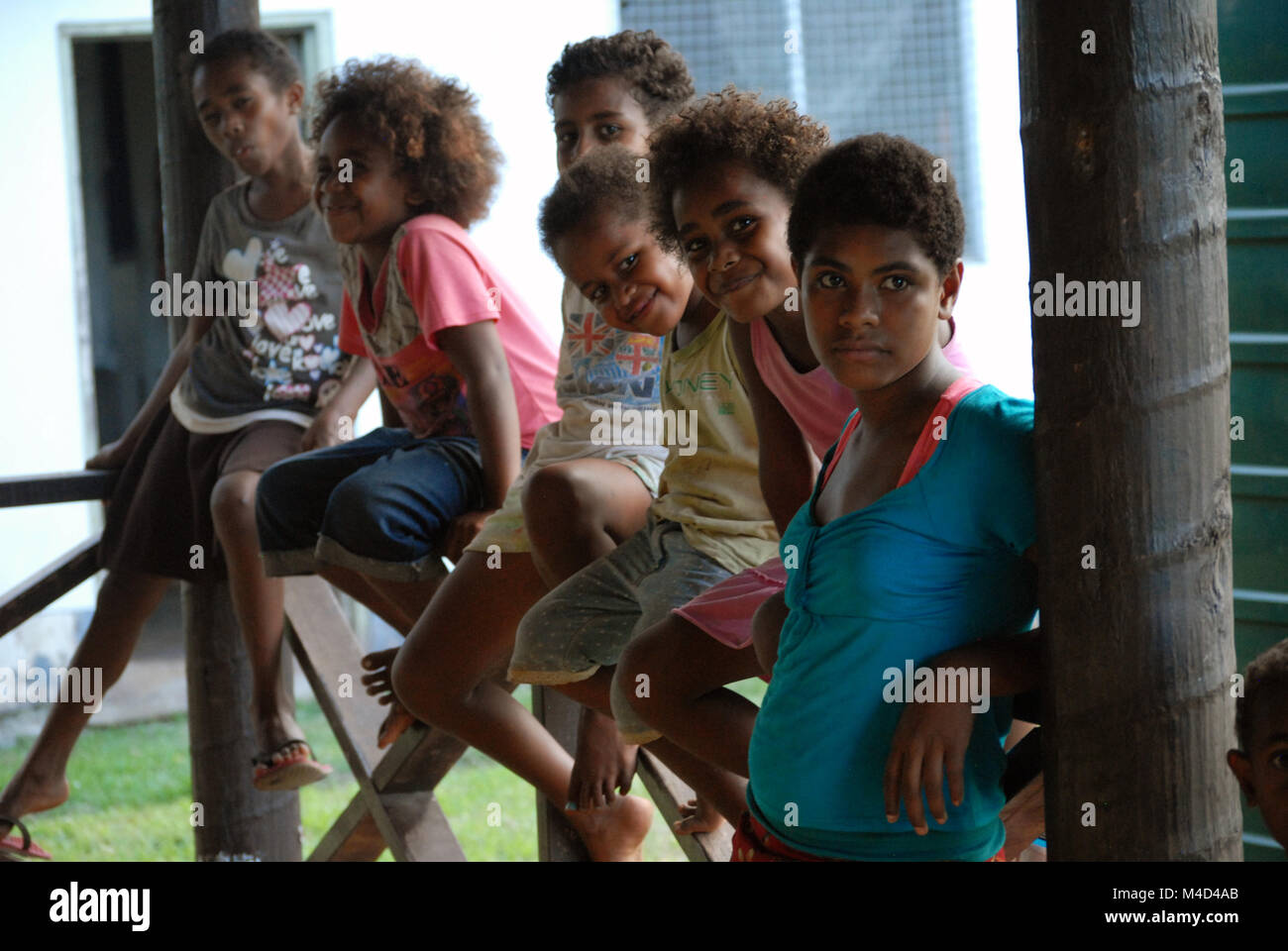 Young Fijian girls sat on fence, Rakiraki, Fiji Stock Photo - Alamy
