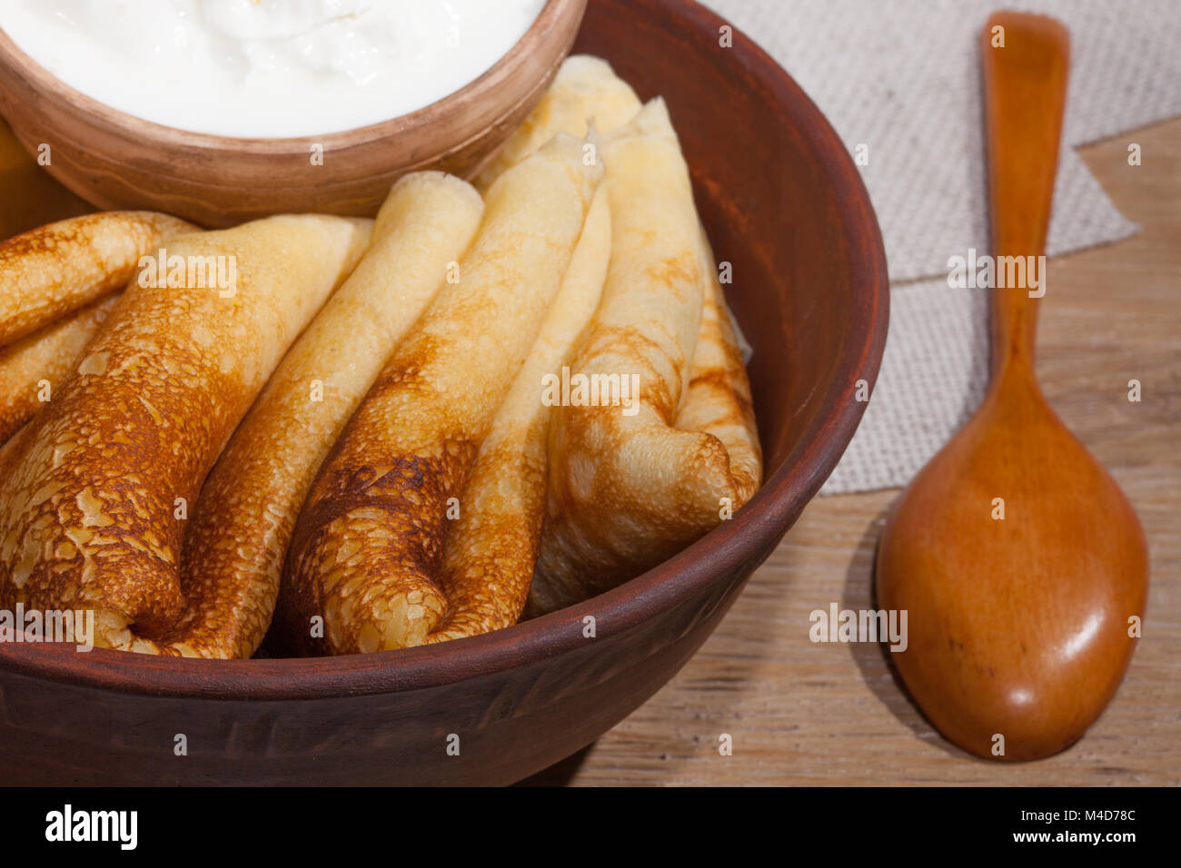 traditional oily food in vintage style: pancakes with sour cream in and ...