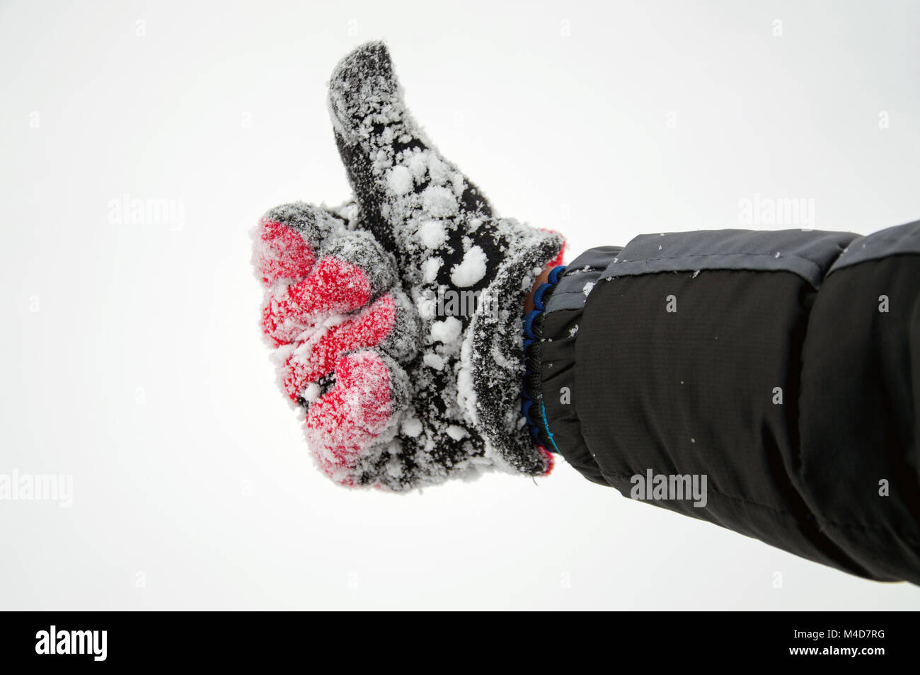 A red gloved hand showing a thumbs up in the snow Stock Photo - Alamy