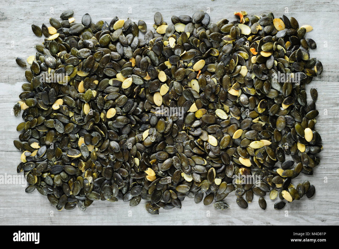 pumpkeen seeds scattered over stone board Stock Photo - Alamy