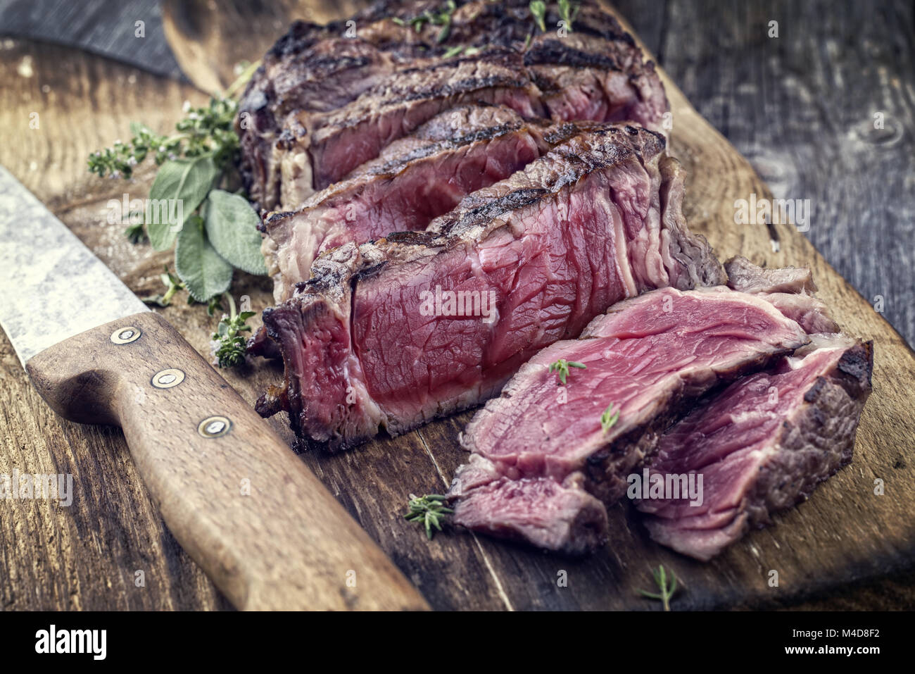 Barbecue Rib Eye Steak sliced on Cutting Board Stock Photo - Alamy
