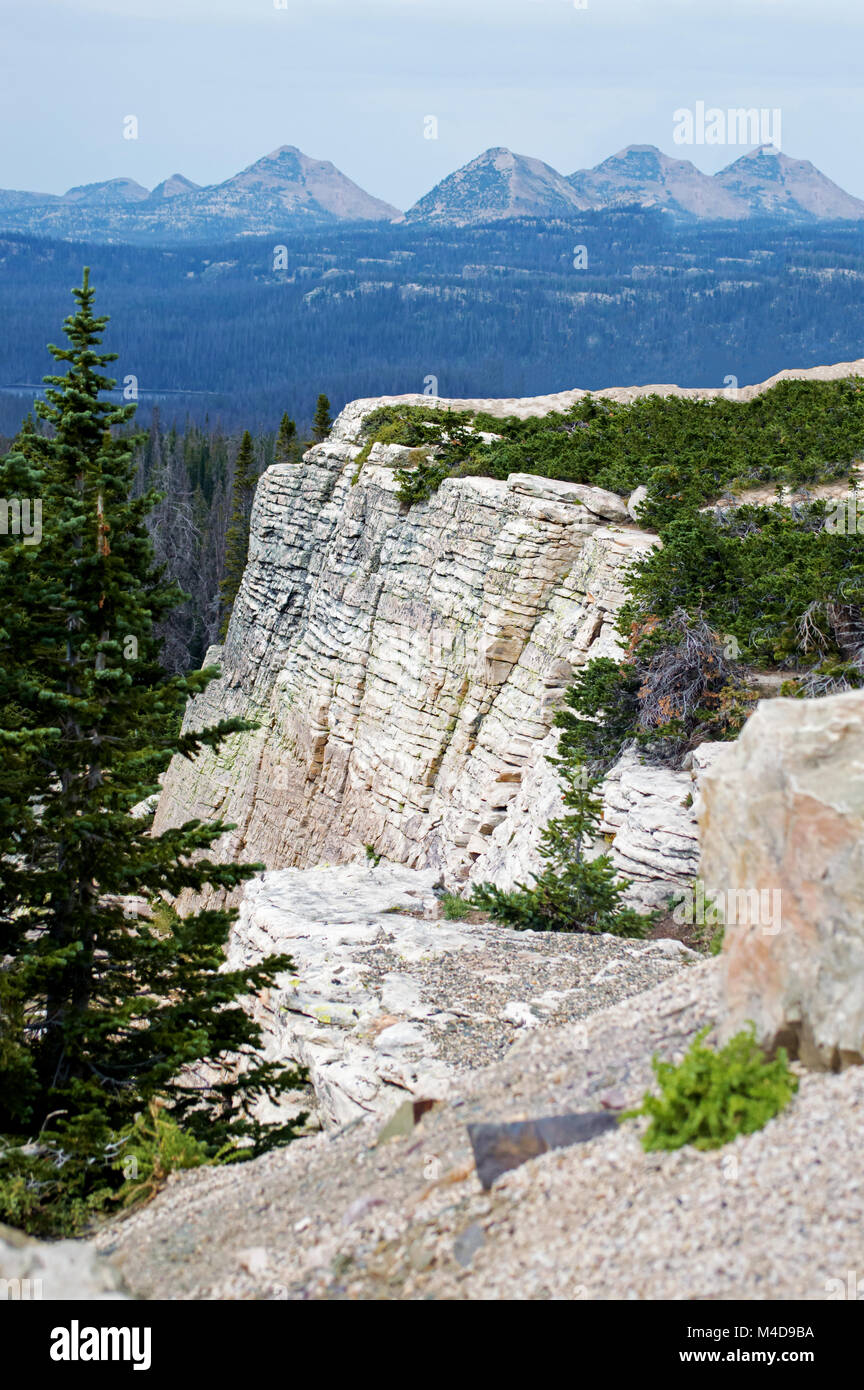 A rocky cliff with mountains in the distance Stock Photo - Alamy