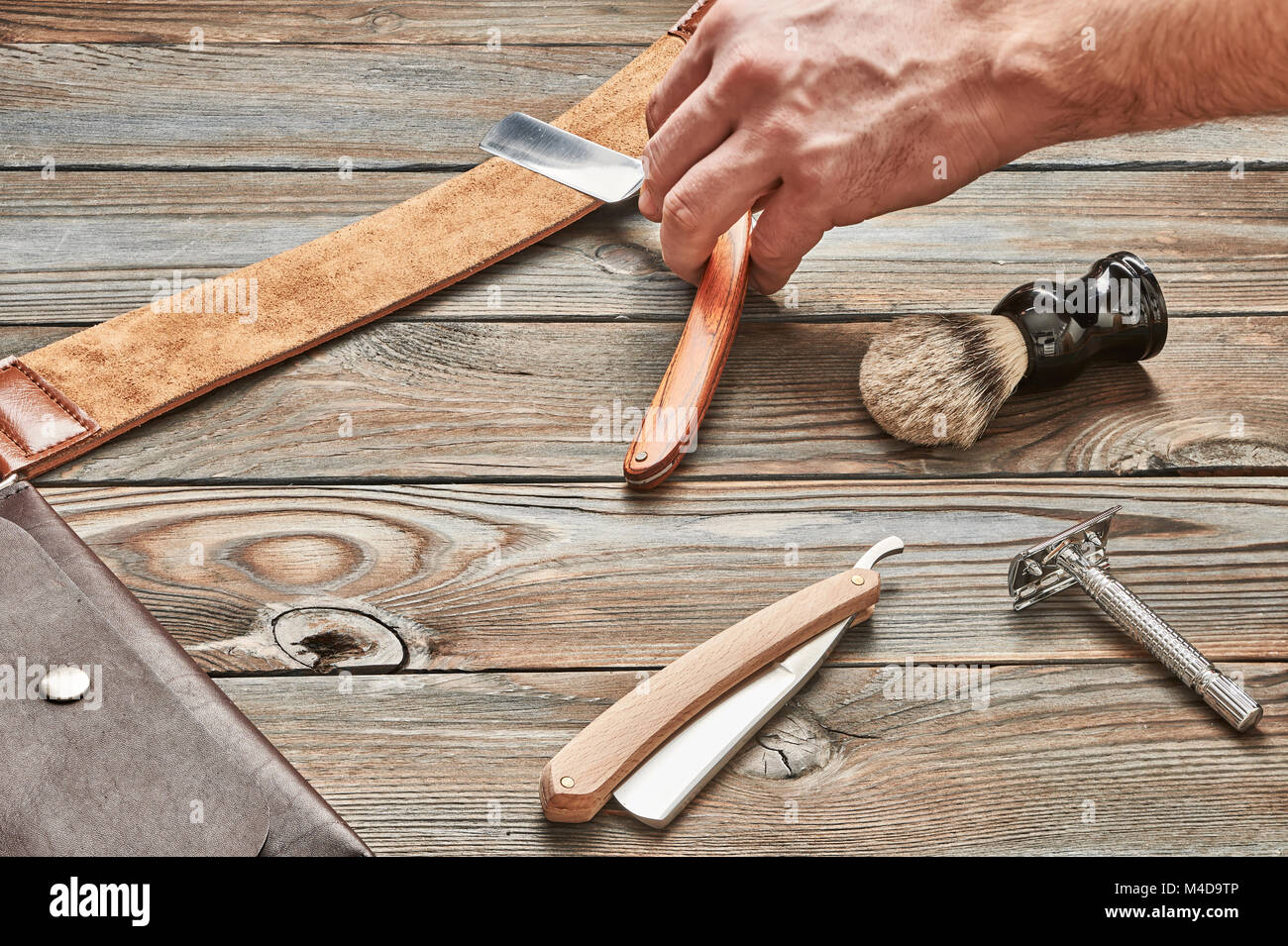 Man stropping straight razor with leather tool Stock Photo - Alamy