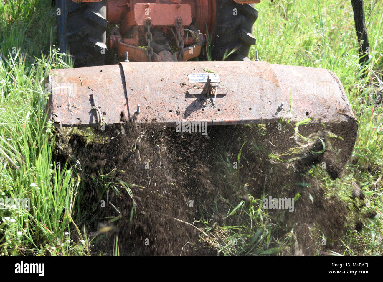 plowing of the soil with old rotary hoe Stock Photo - Alamy