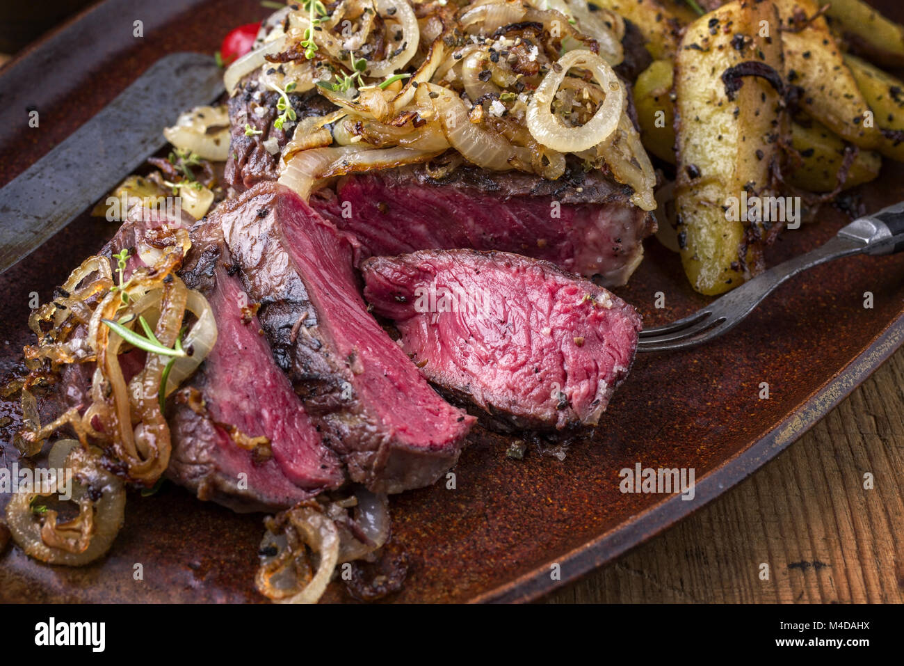 Wagyu Rib-Eye Steak Bleu with Fried Onion and Potatoes Stock Photo - Alamy