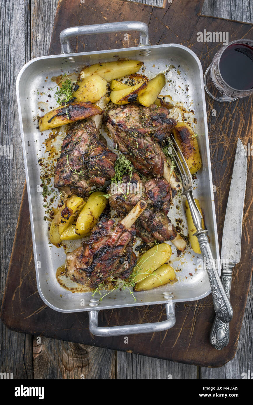 Barbecue Lamb Knuckles with Fried Potatoes in Roasting Dish Stock Photo ...