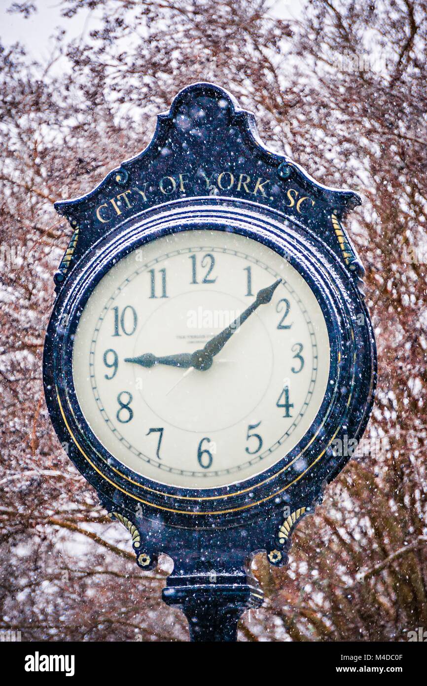 vintage historic street clock with snow falling in winter Stock Photo ...