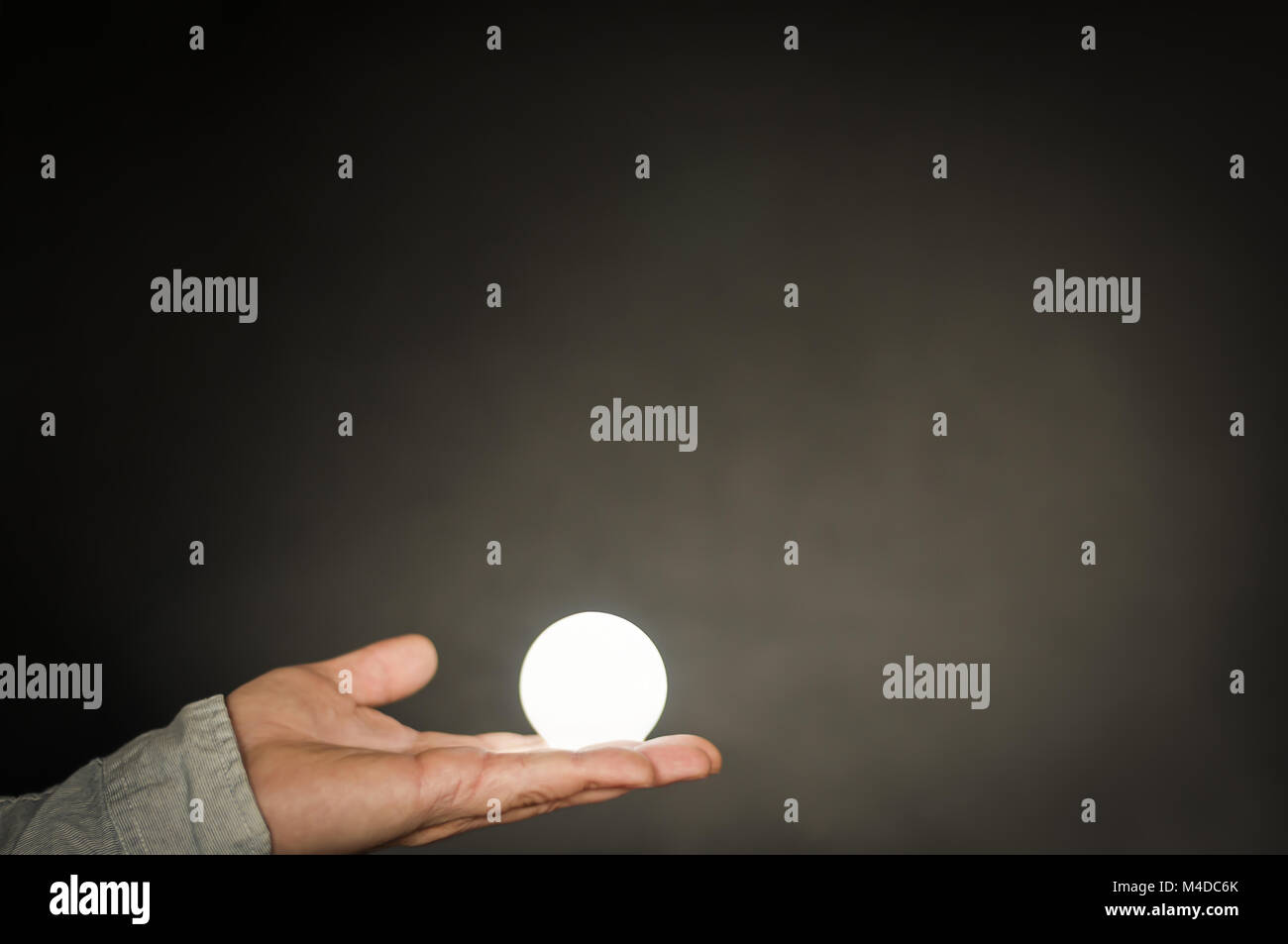 Hand with light bulb Stock Photo - Alamy