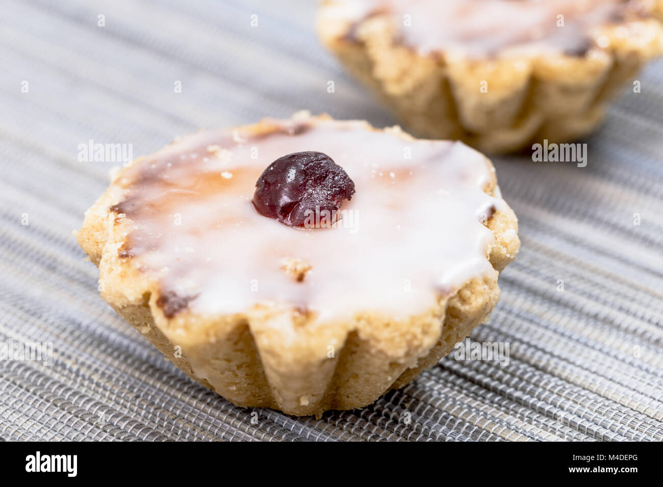 Marzipan pastry with sugar glaze and candied cherry Stock Photo - Alamy