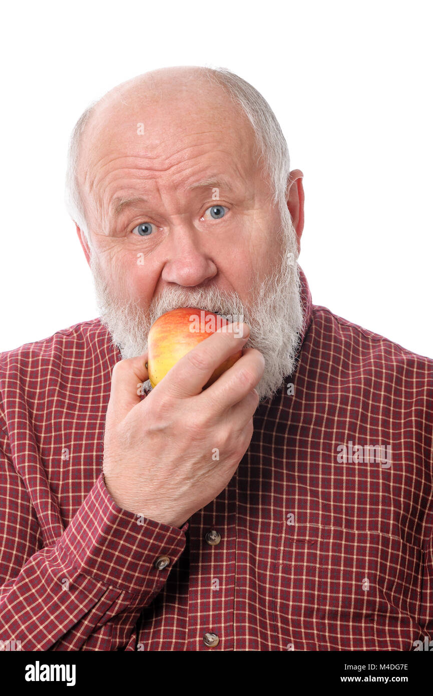 Cheerfull senior man eating the apple, isolated on white Stock Photo ...