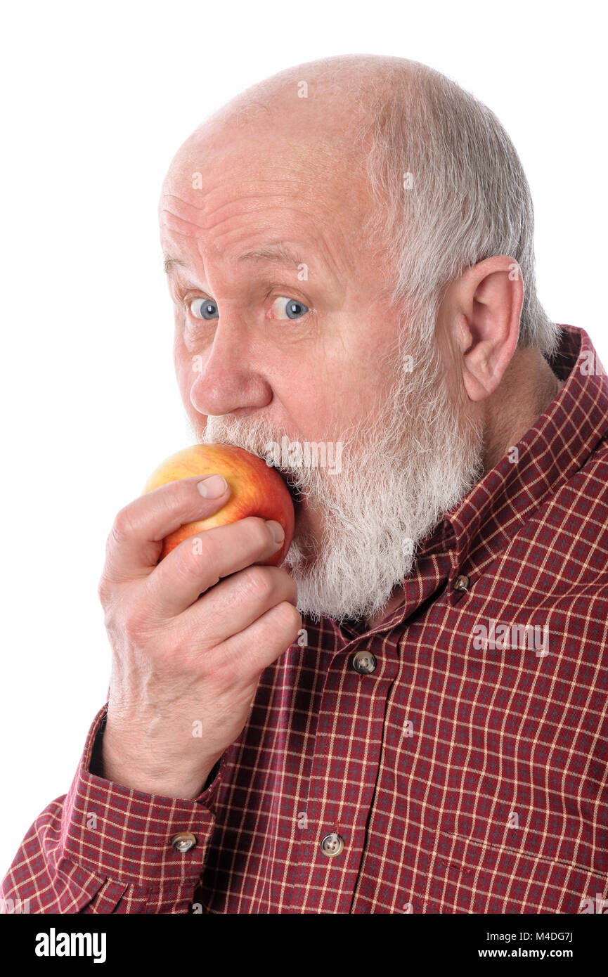 Cheerfull senior man eating the apple, isolated on white Stock Photo ...