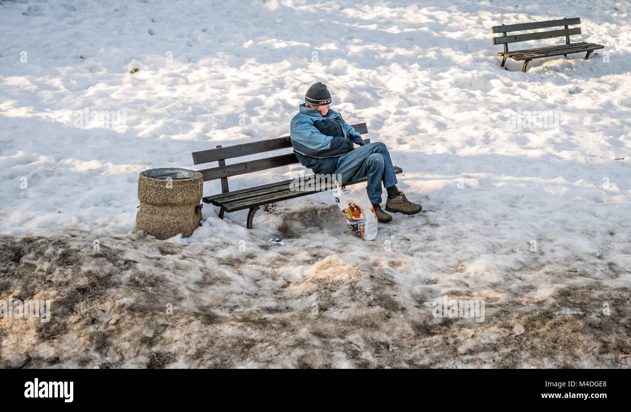 Homeless man on a bench Stock Photo - Alamy