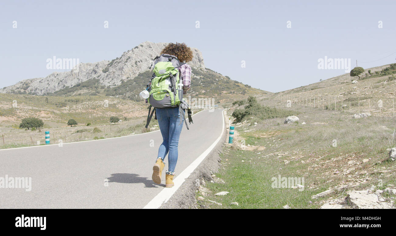 Back view of woman walking down road Stock Photo - Alamy