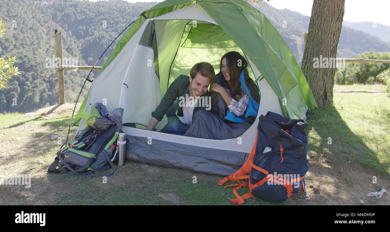 Smiling couple having fun in tent Stock Photo - Alamy