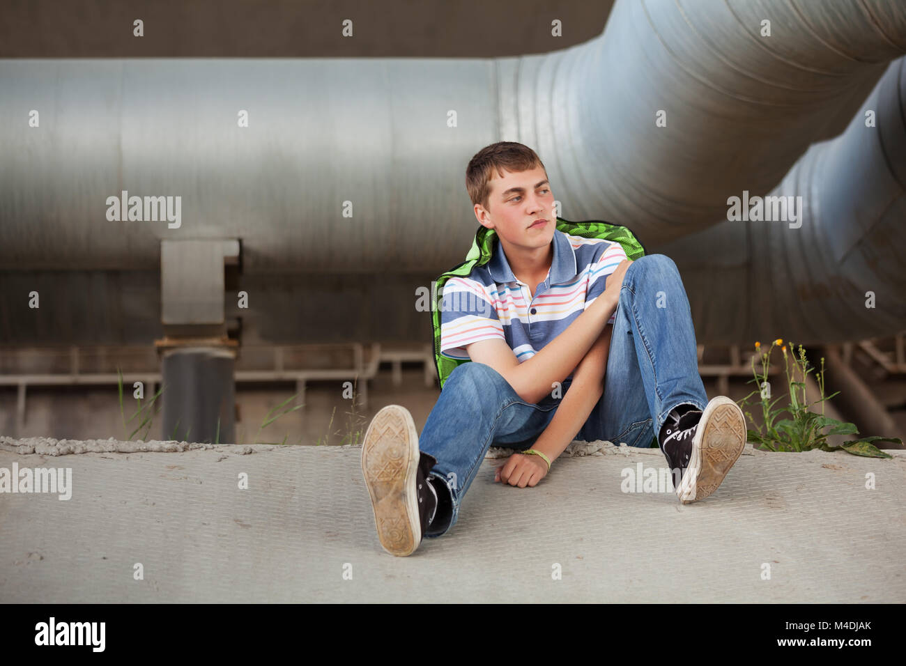 Sad teen boy in depression sitting on the ground outdoor Stock Photo ...