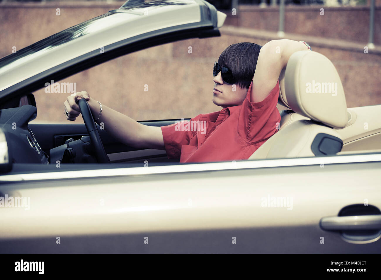 Young man driving a convertible car Stock Photo - Alamy