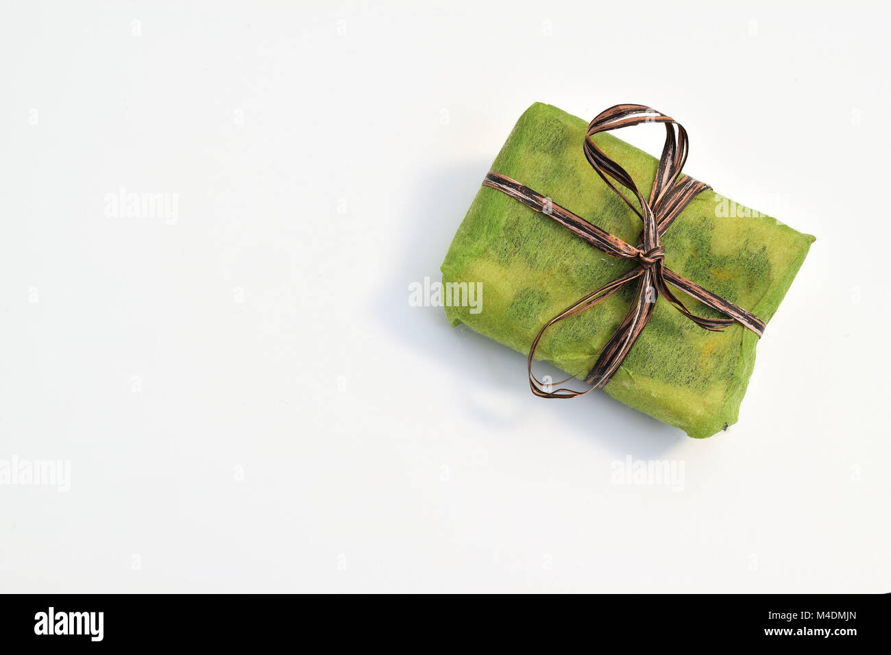 Small green gift boxes with brown ribbon Stock Photo - Alamy