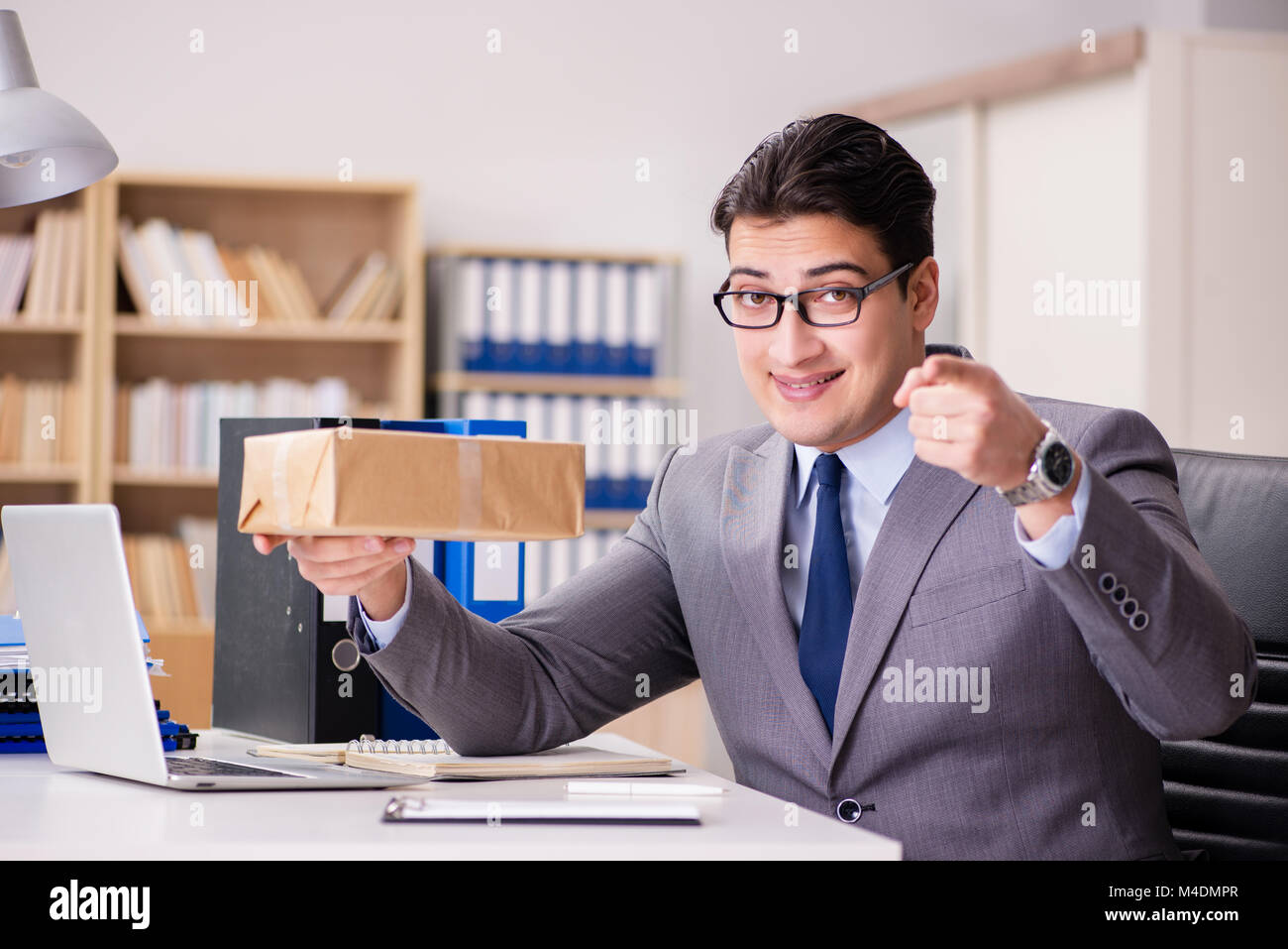 The businessman receiving parcel in the office Stock Photo - Alamy