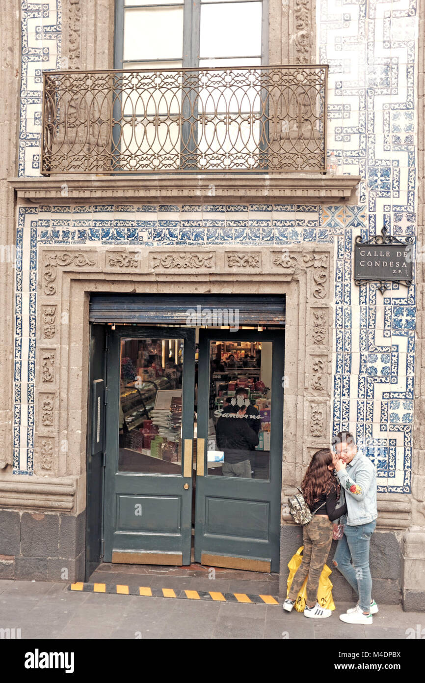 A couple stands outside the Casa de Los Azulejos (House of Blue Tiles ...