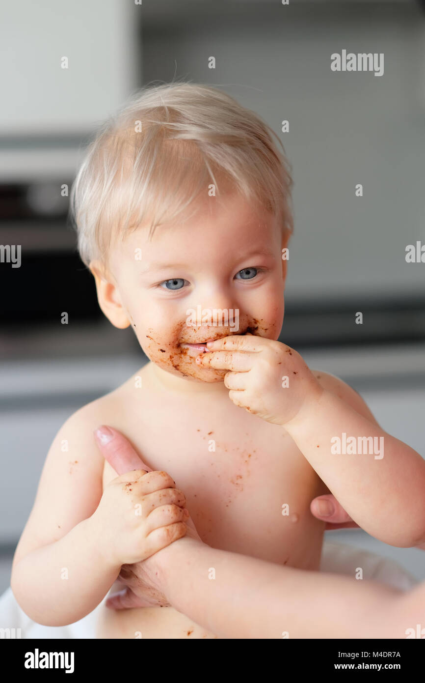 Toddler baby boy child eating fruit with dirty messy face Stock Photo ...