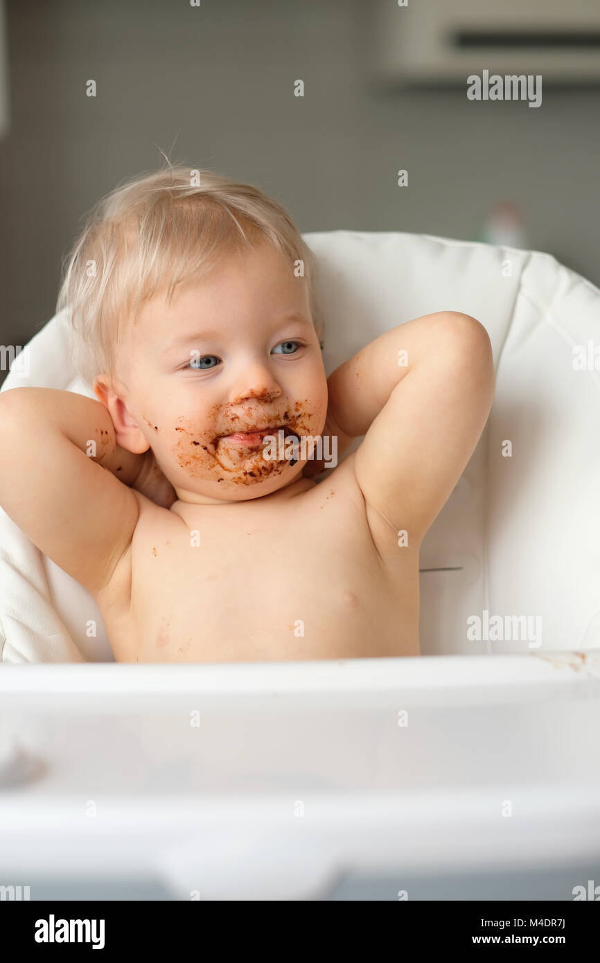 Toddler baby boy child eating fruit with dirty messy face Stock Photo ...