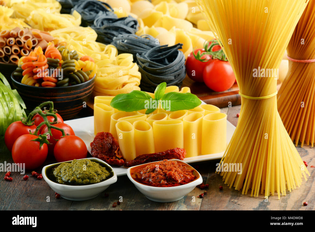 Composition with different sorts of pasta on kitchen table Stock Photo ...