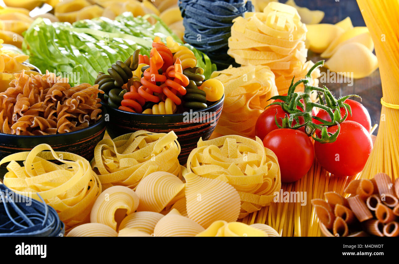 Composition with different sorts of pasta on kitchen table Stock Photo ...