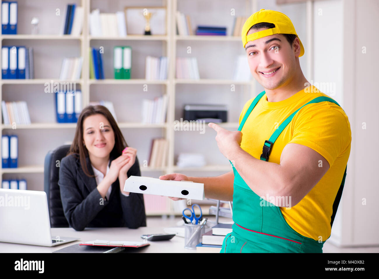 Postman delivering parcel to the office Stock Photo - Alamy