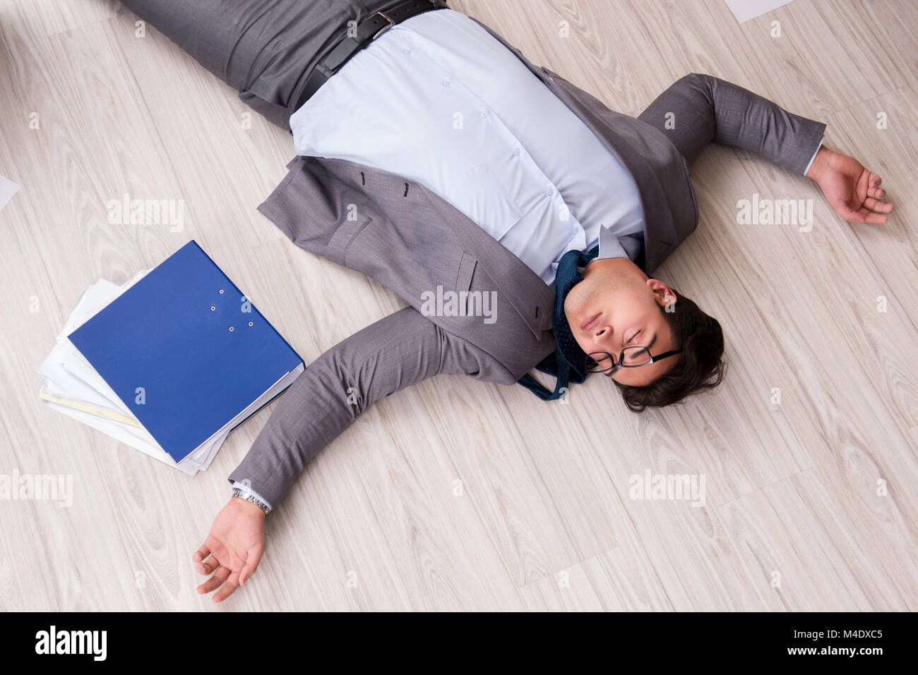 Businessman dead on the office floor Stock Photo - Alamy