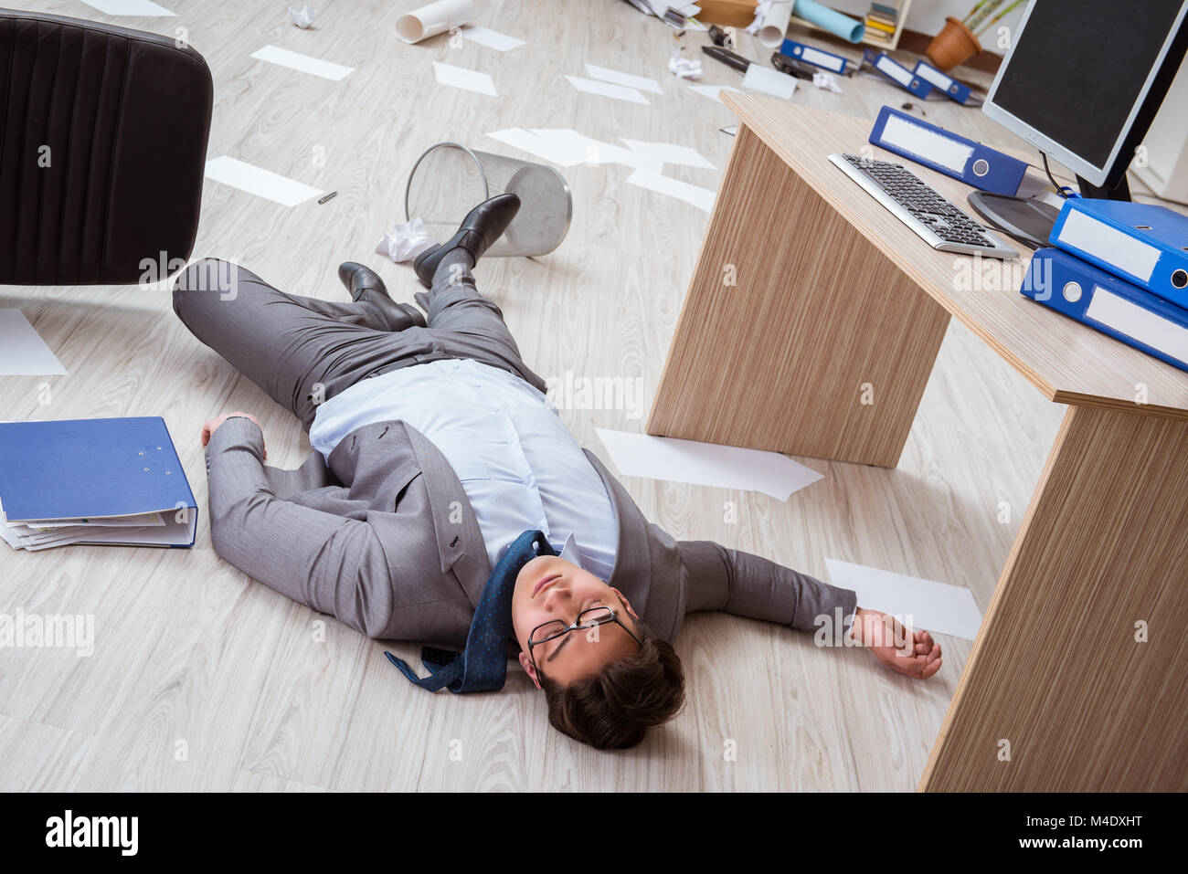 Businessman dead on the office floor Stock Photo - Alamy
