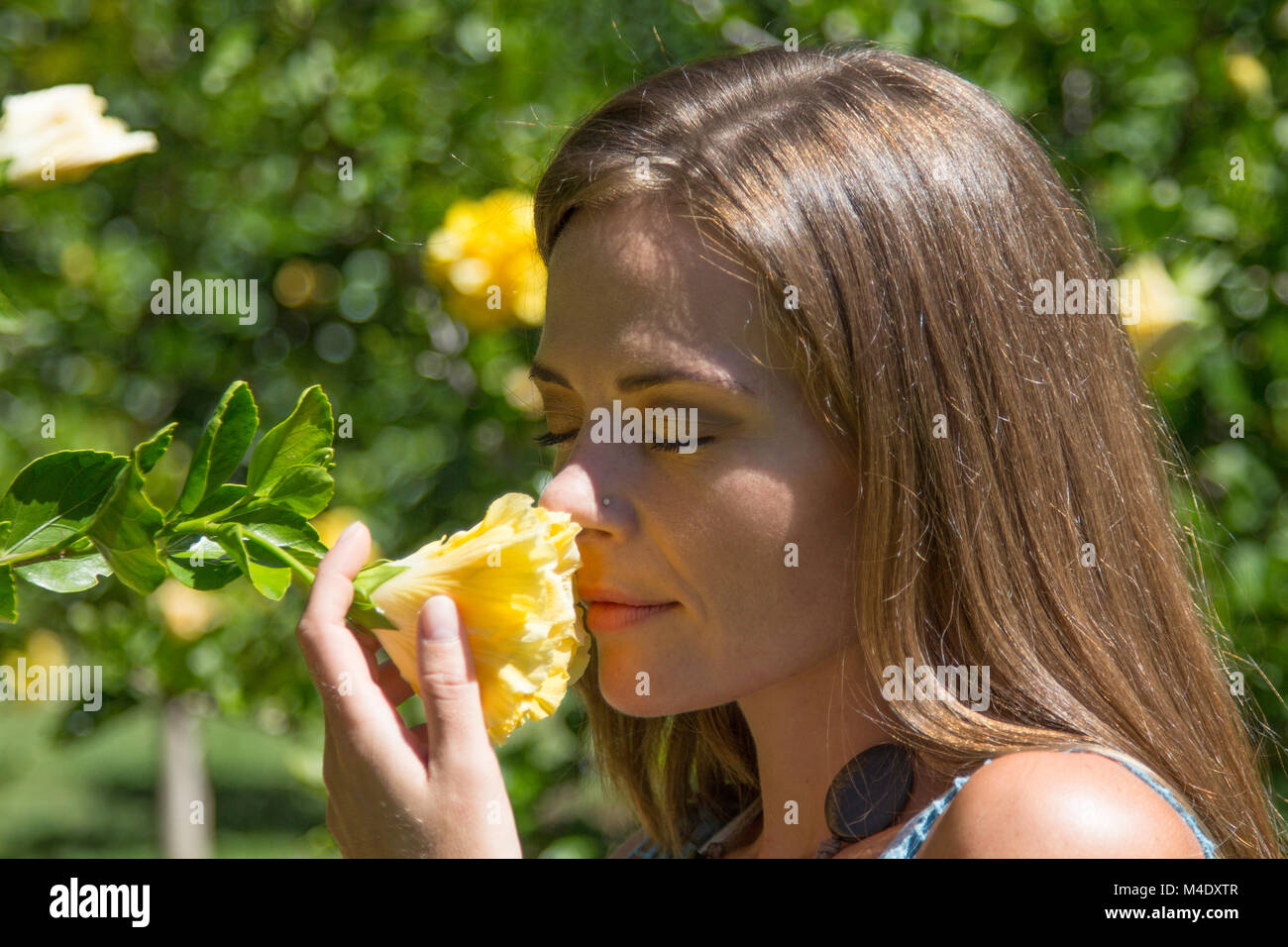 Female smelling the scent of a blossoming flower Stock Photo - Alamy