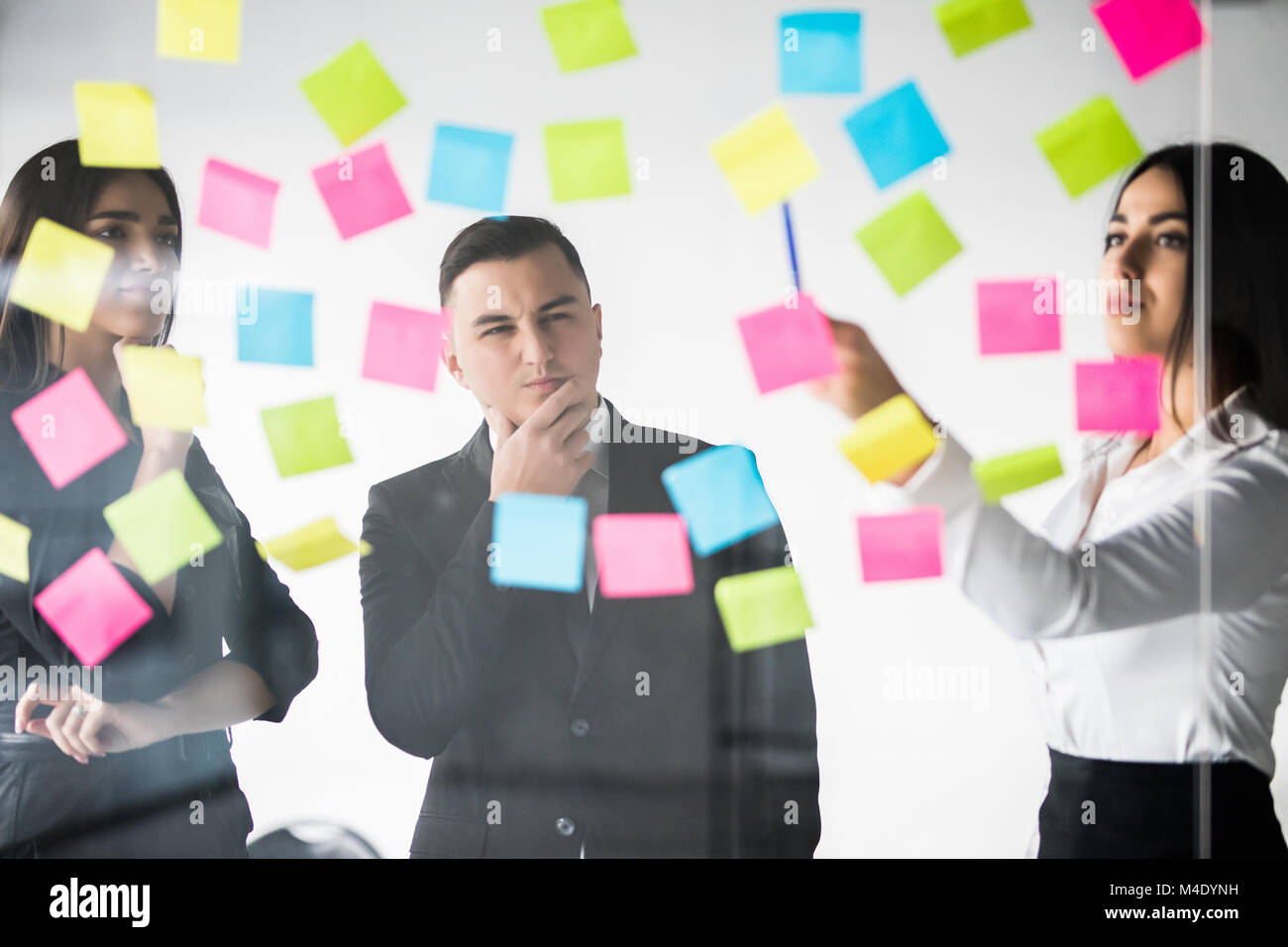happy creative team with stickers on office glass board Stock Photo - Alamy