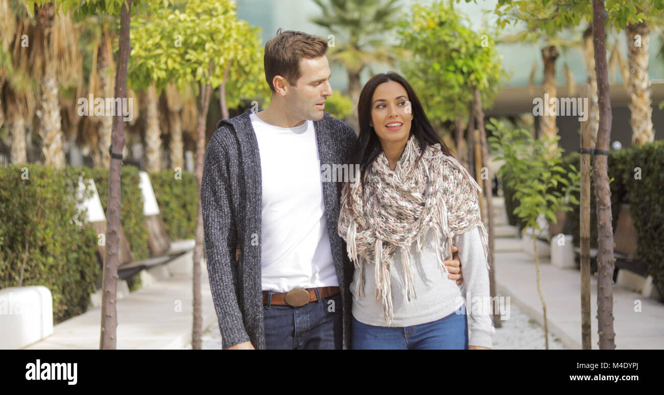 Trendy young couple walking along a promenade Stock Photo - Alamy