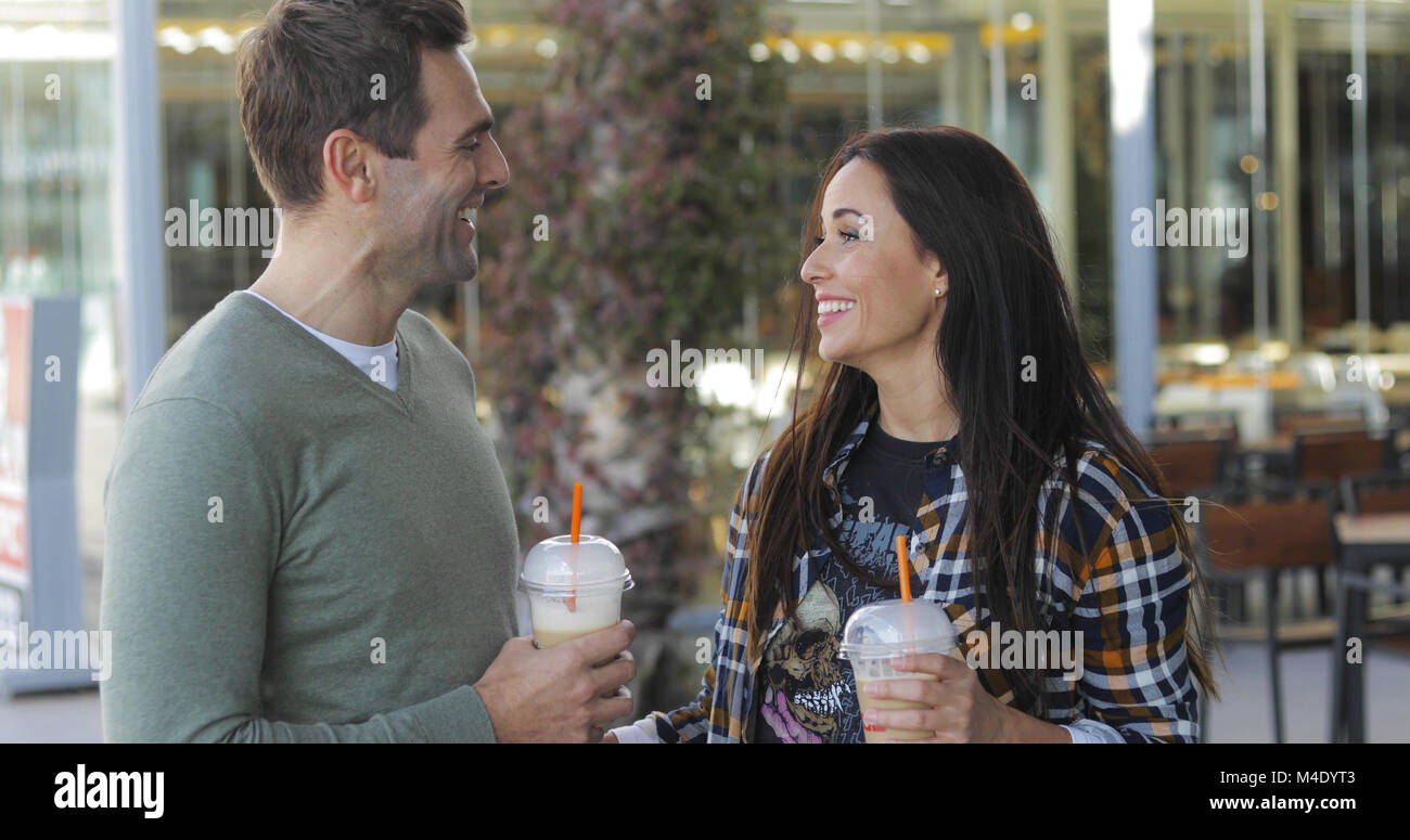 Happy relaxed couple enjoying takeaway coffee Stock Photo - Alamy