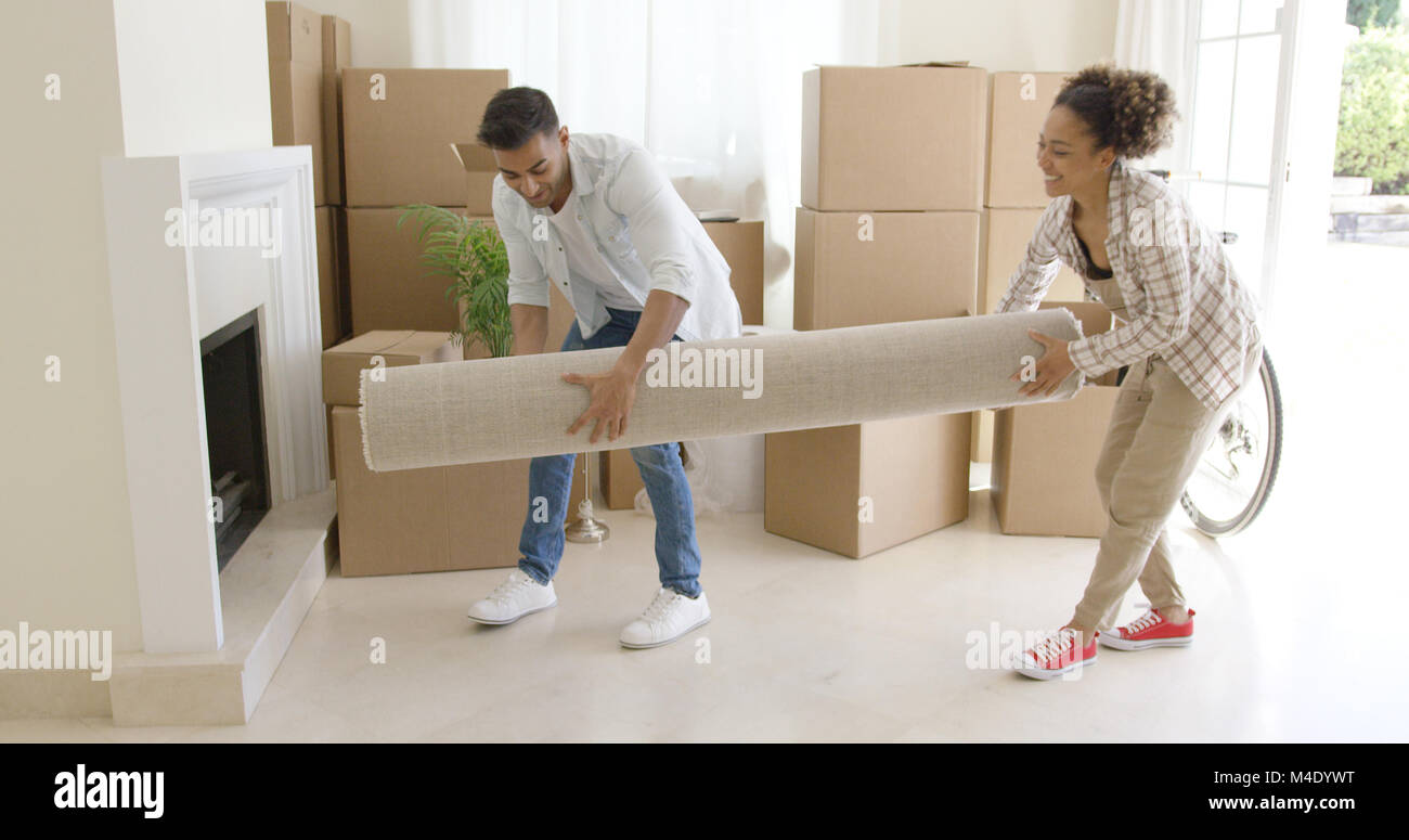 Young couple carrying a rolled rug into a house Stock Photo - Alamy