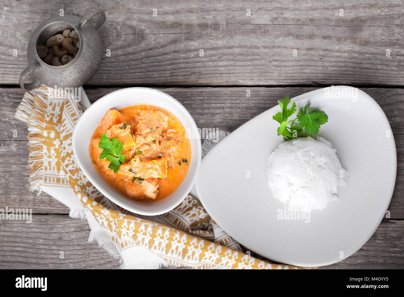 Chicken curry and rice served on a wooden surface Stock Photo - Alamy
