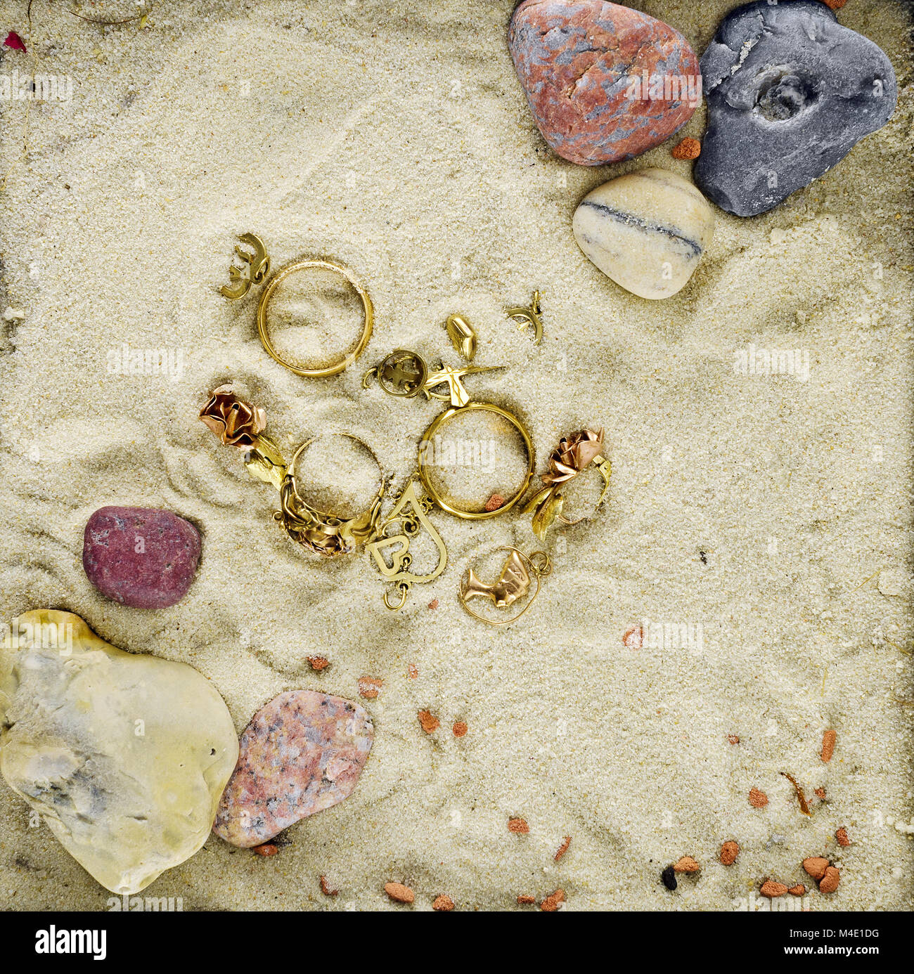 gold jewelry with sand and stones Stock Photo - Alamy