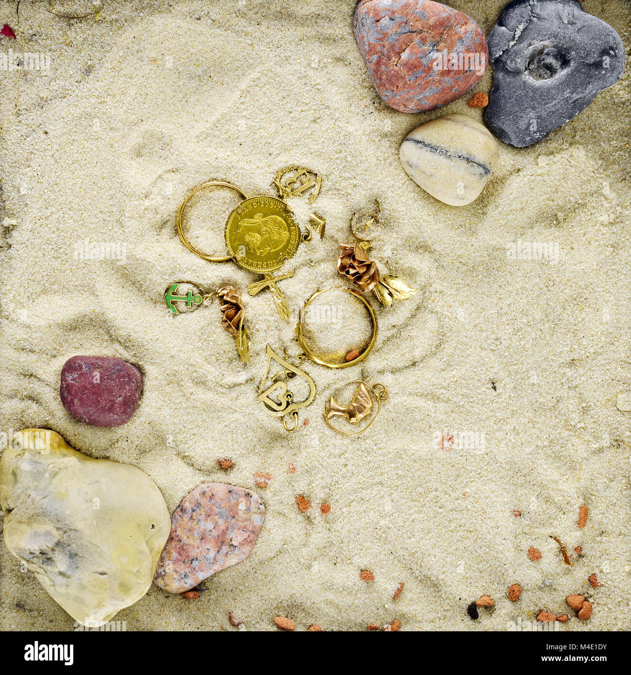 gold jewelry with sand and stones Stock Photo - Alamy