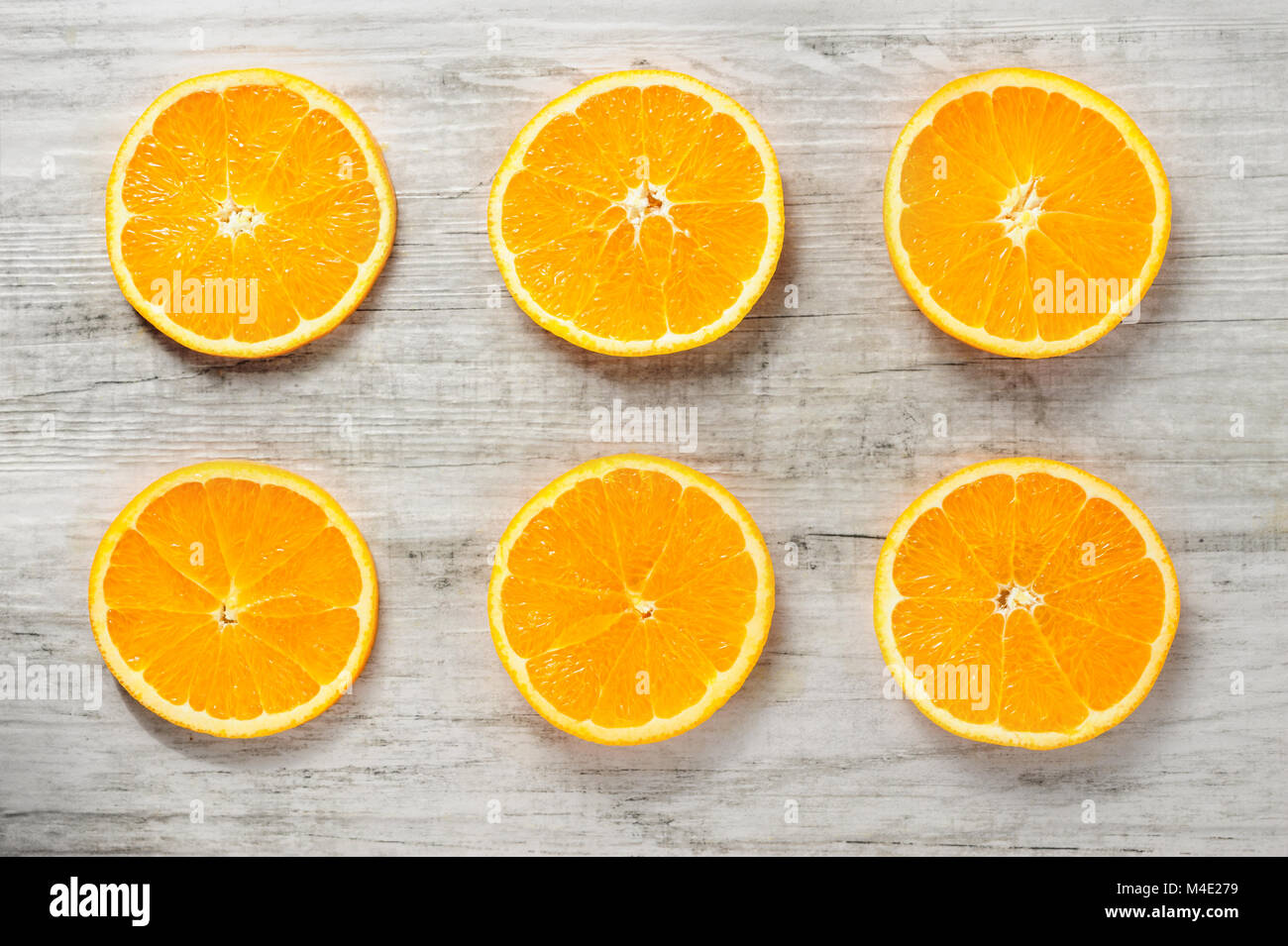 Six slices of fresh oranges on white wood background Stock Photo - Alamy