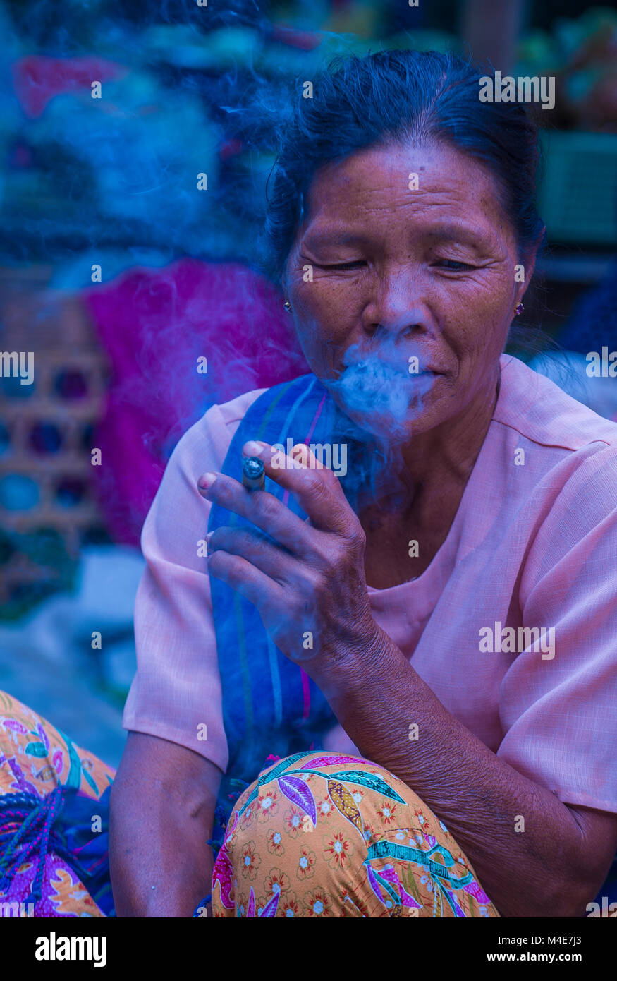 Woman smoking a cheroot cigar in market in bagan, Myanmar Stock Photo ...