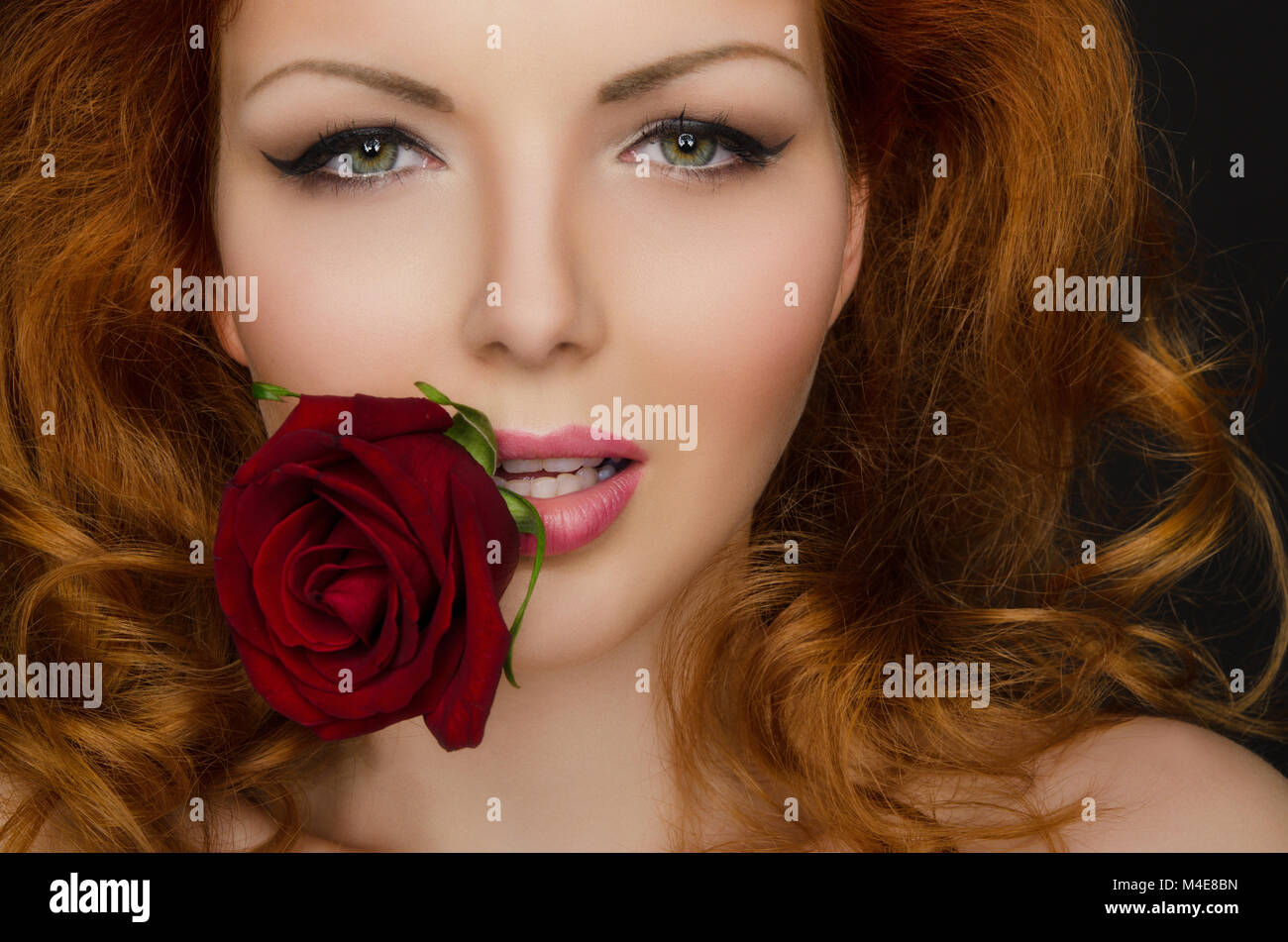 rose in the teeth of woman with beautiful hair Stock Photo - Alamy
