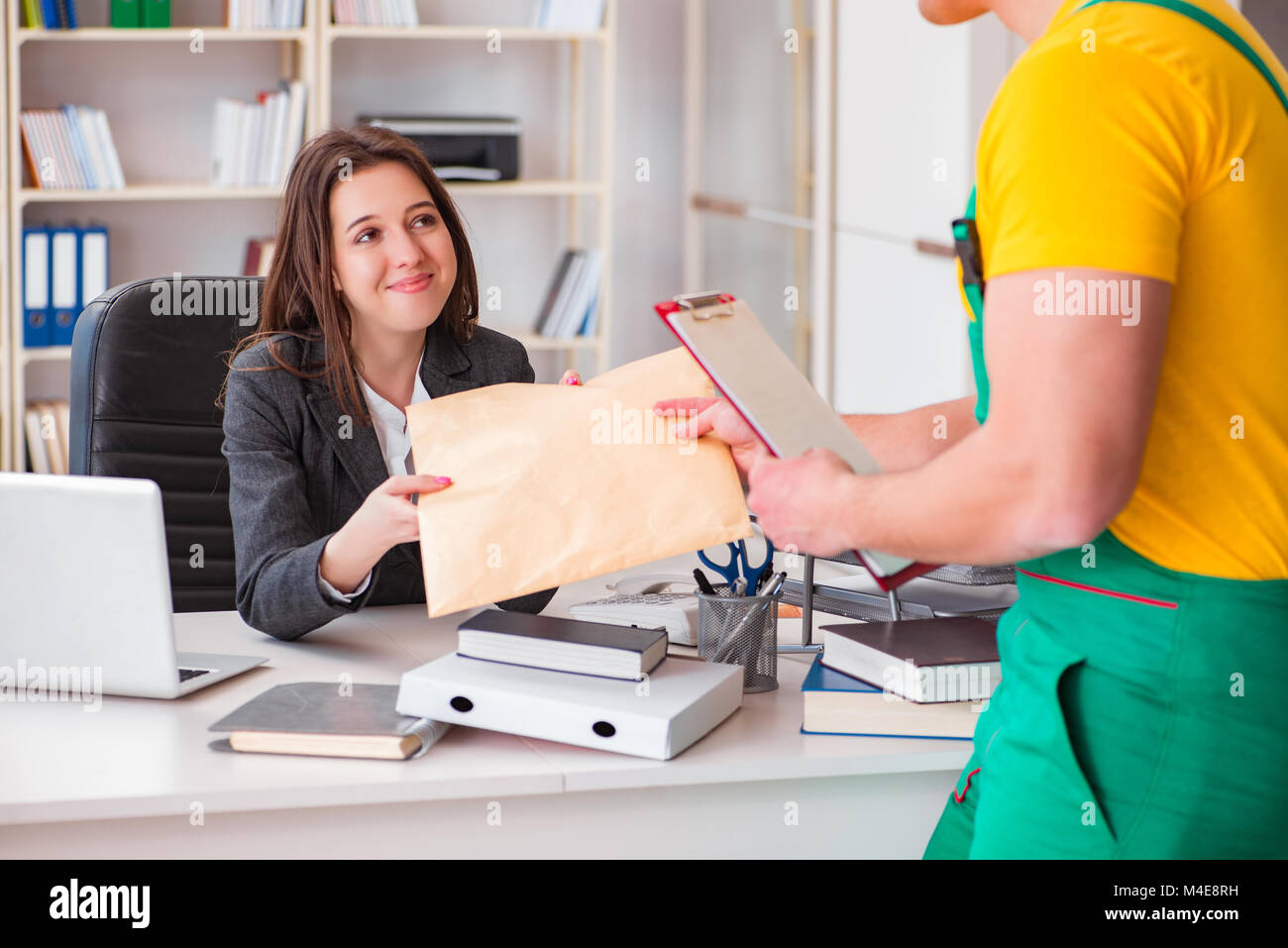 Postman delivering parcel to the office Stock Photo - Alamy