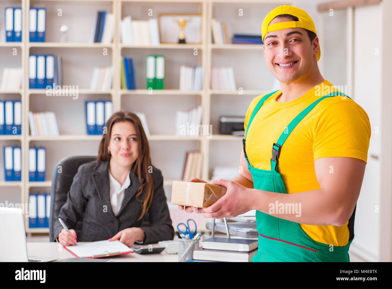 Postman delivering parcel to the office Stock Photo - Alamy