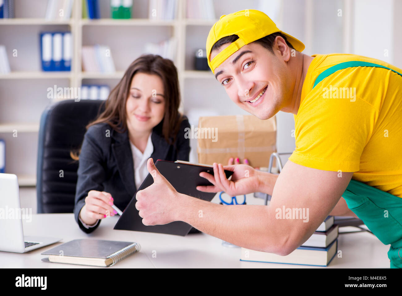 Postman delivering parcel to the office Stock Photo - Alamy