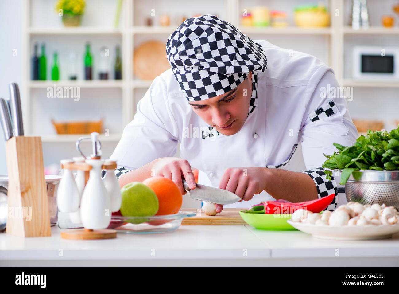 Young male cook working in the kitchen Stock Photo - Alamy