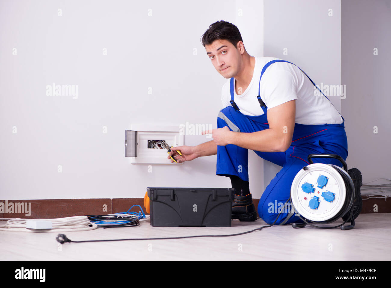 Young electrician working on socket at home Stock Photo - Alamy