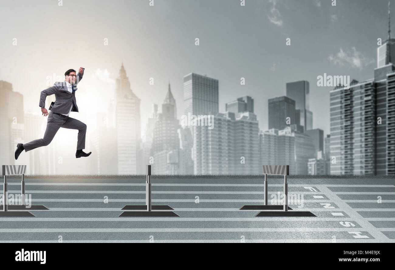 Businessman jumping over barriers in business concept Stock Photo - Alamy