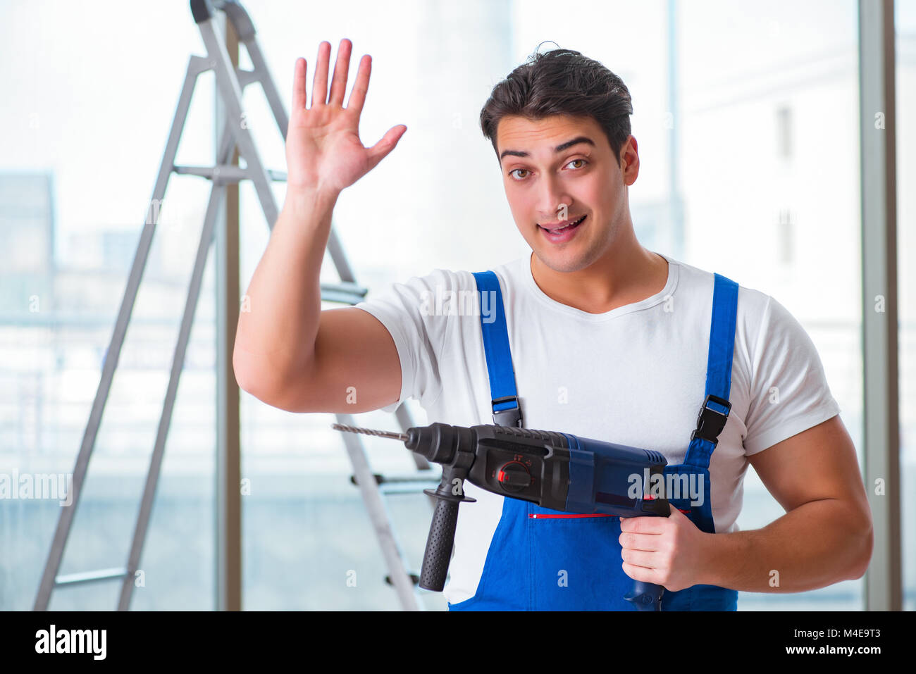 Young worker with hand drill Stock Photo - Alamy