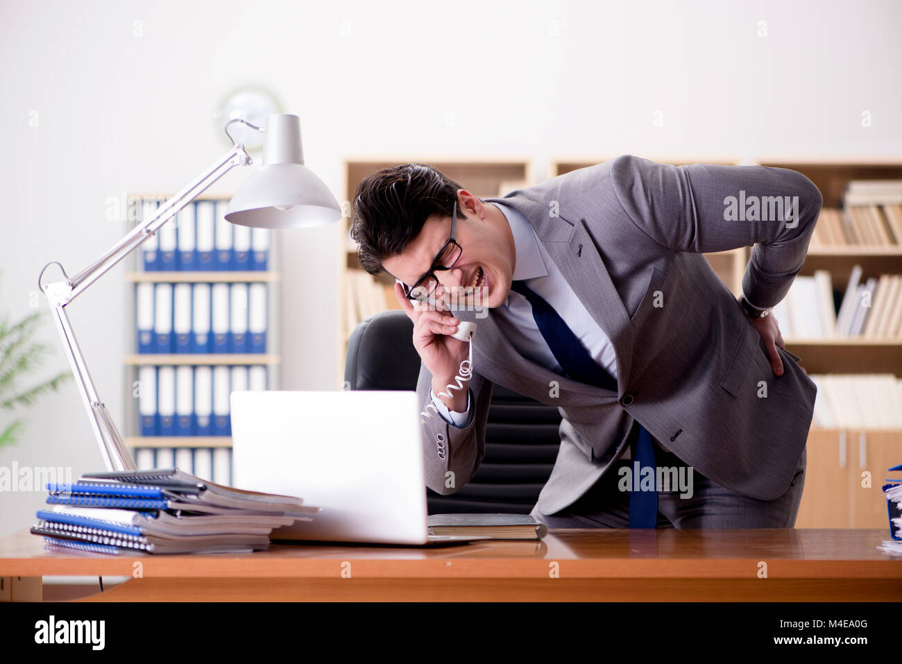 Businessman feeling pain in the office Stock Photo - Alamy